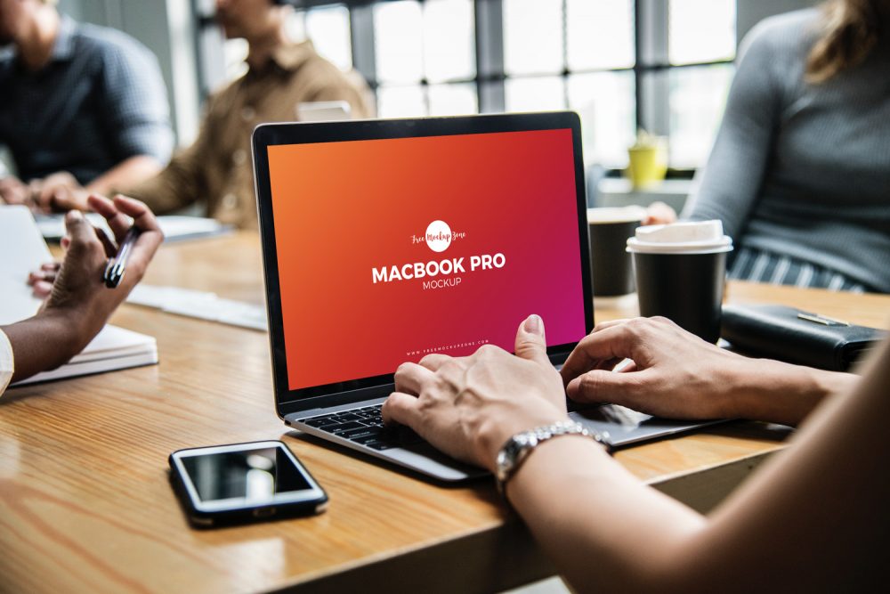 Free Person Using MacBook Pro Mockup PSD